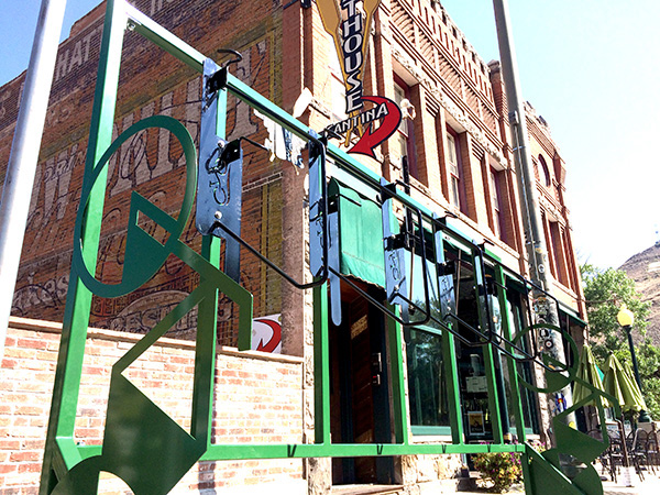 Vertical bike rack on sidewalk provides parking and artwork